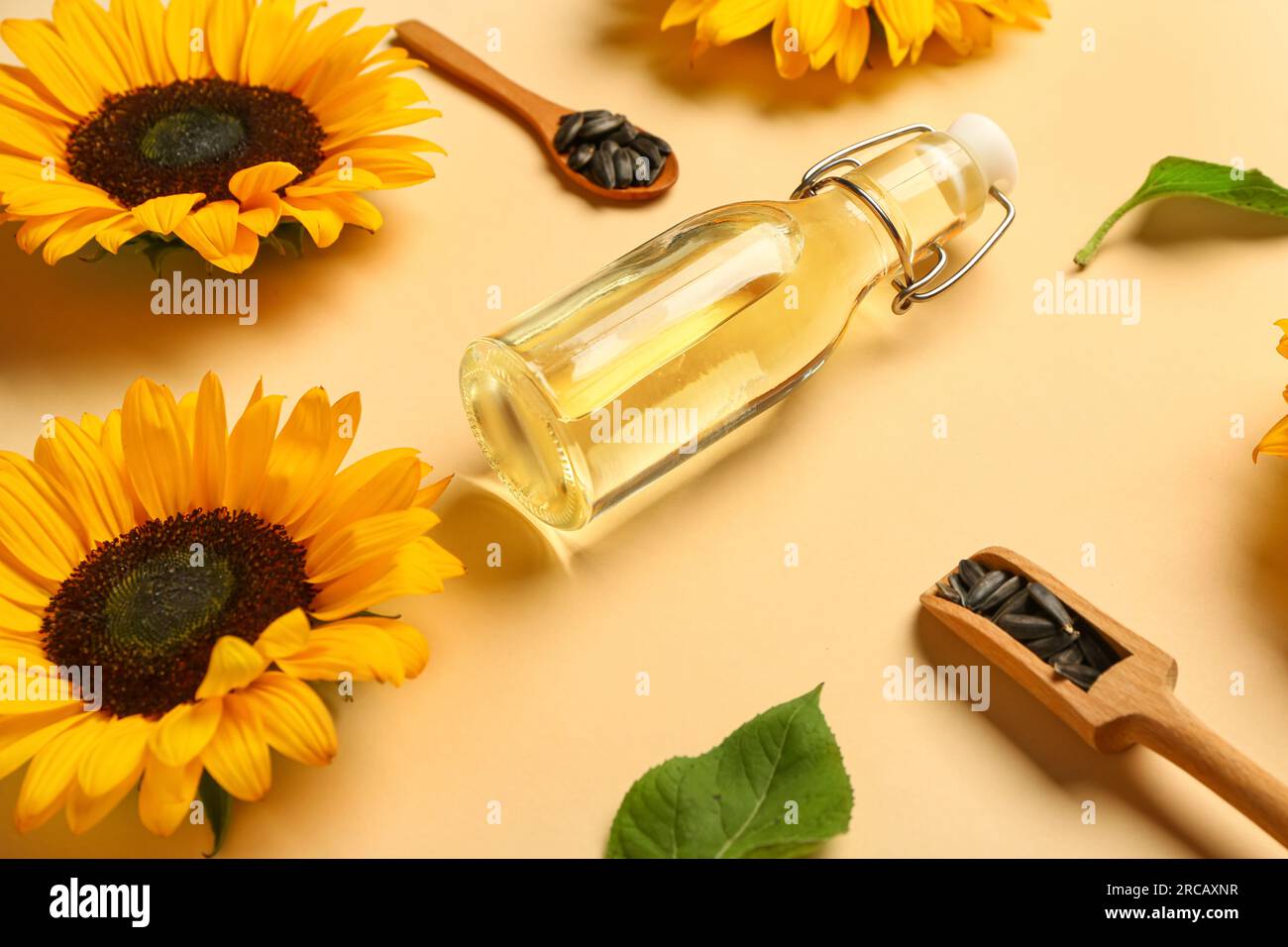 Sunflowers, seeds and bottle of oil on yellow background Stock Photo ...