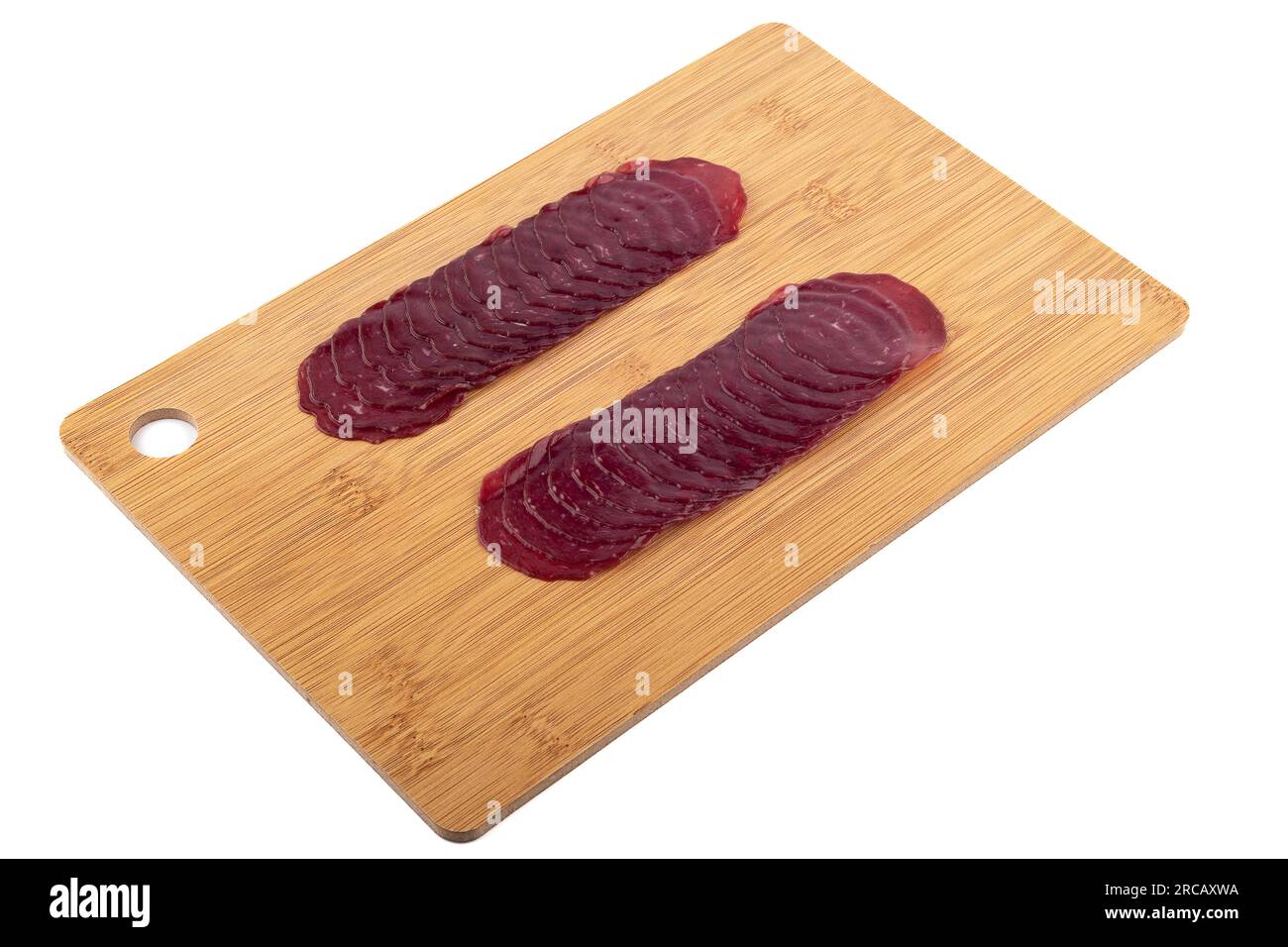 Sliced pastrami on a cutting board over a white background. Copy space ...