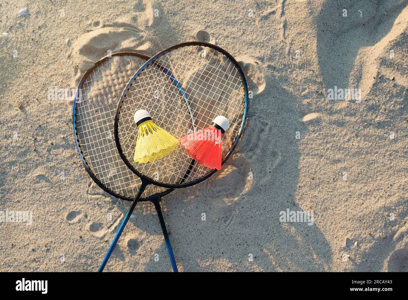 Badminton rackets and shuttlecock on the sand, top view. Summer ...