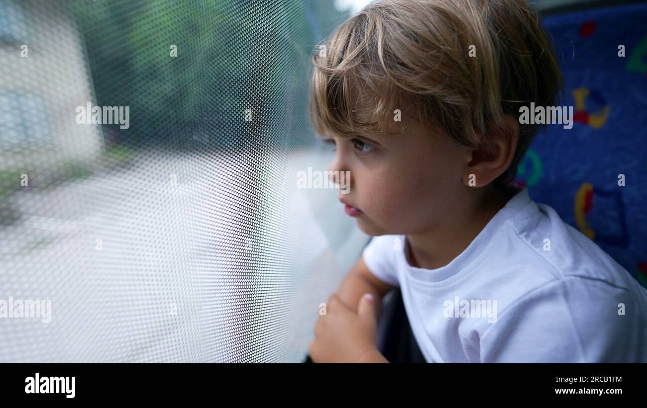 One passenger little boy traveling by bus looking out vehicle window ...