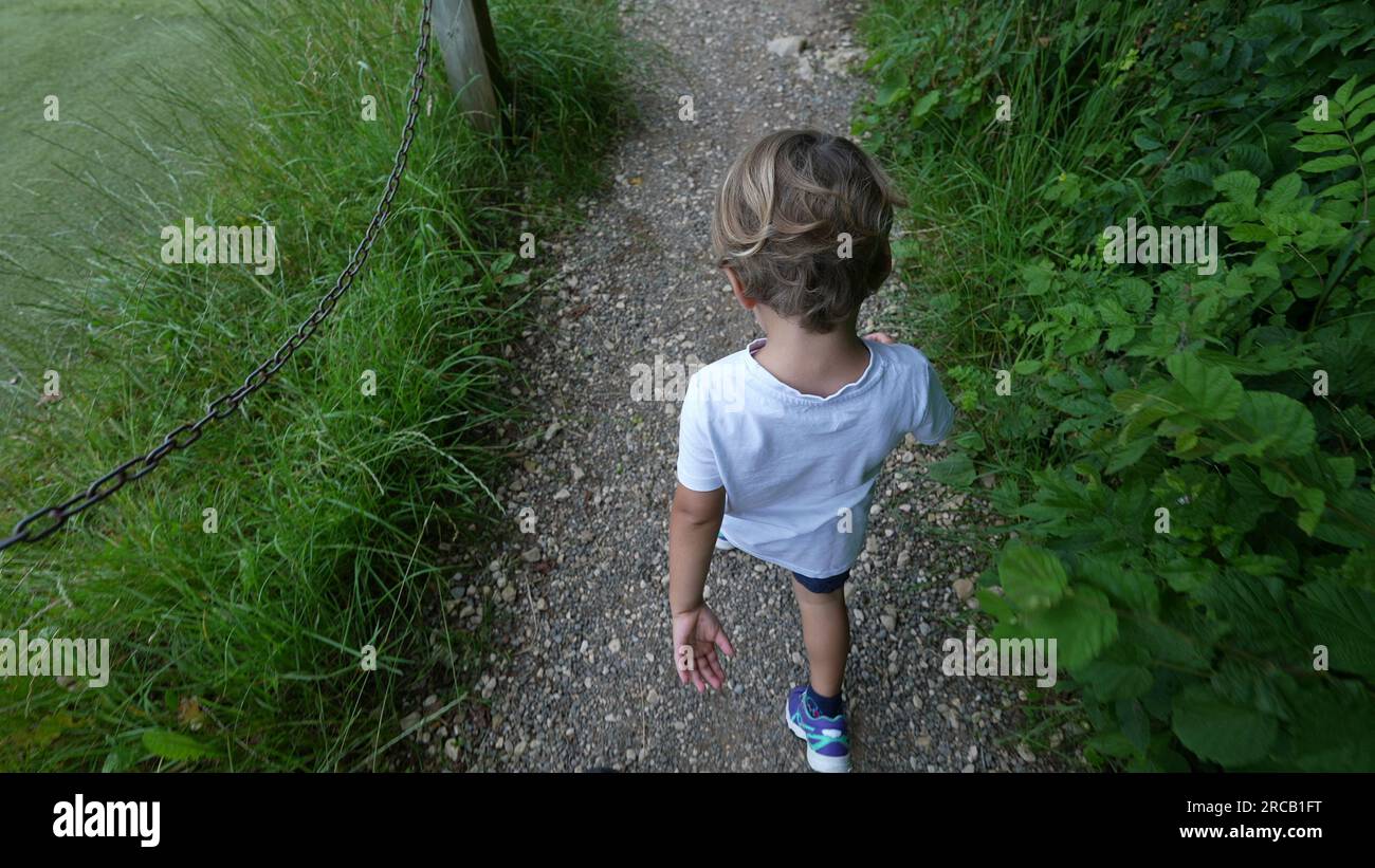 One sad little boy walking outside with head down Stock Photo - Alamy