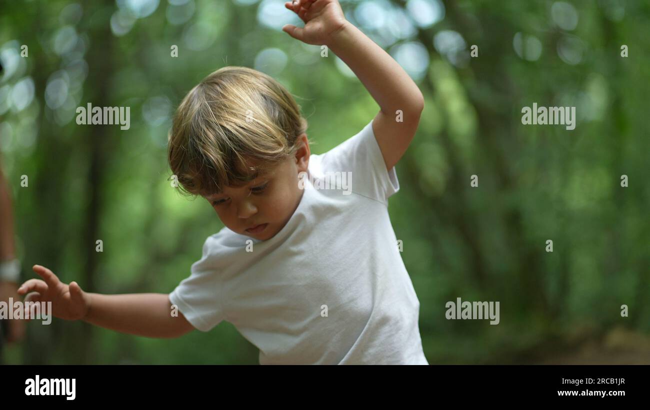 Small boy hiking going up hill outside in nature child stepping on ...