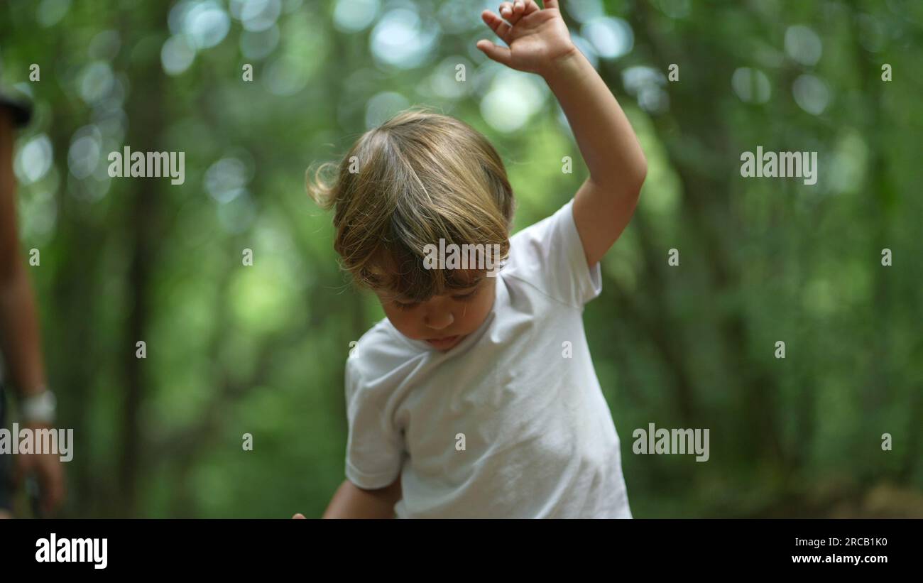 Small boy hiking going up hill outside in nature child stepping on ...
