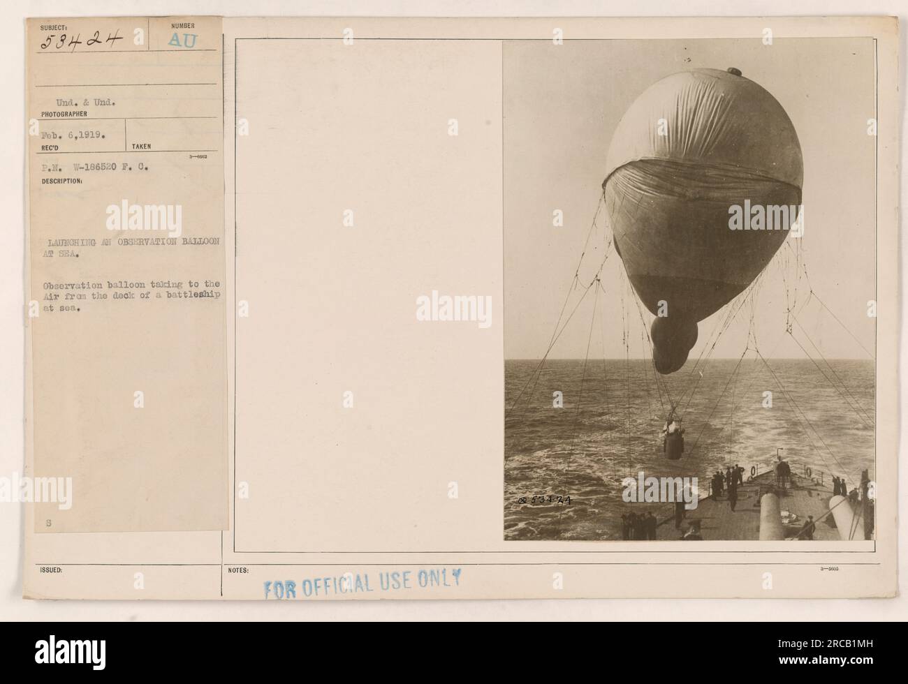 Observation balloon being launched from the deck of a battleship at sea ...