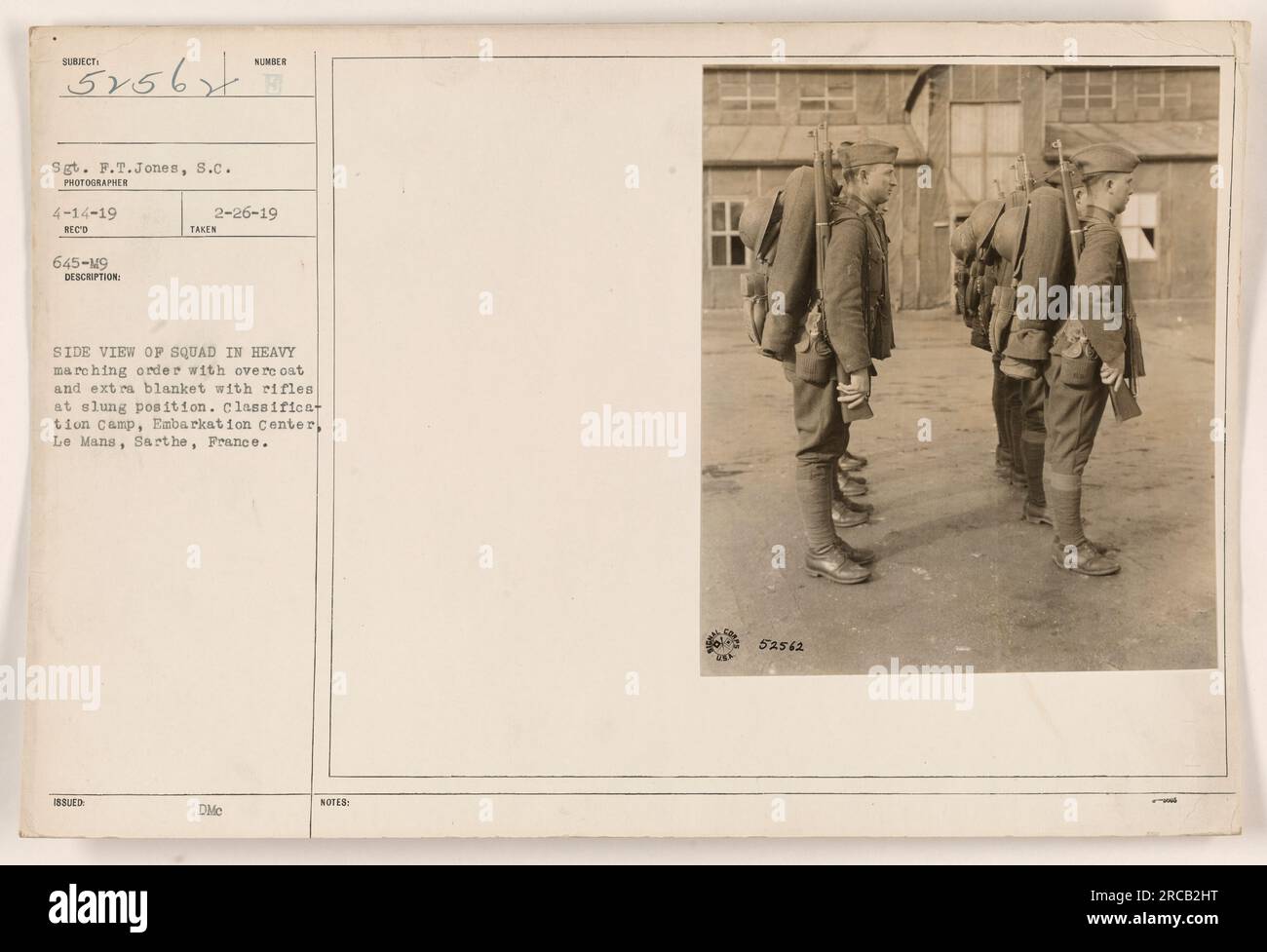 Squad in heavy marching order with overcoat and extra blanket, holding ...