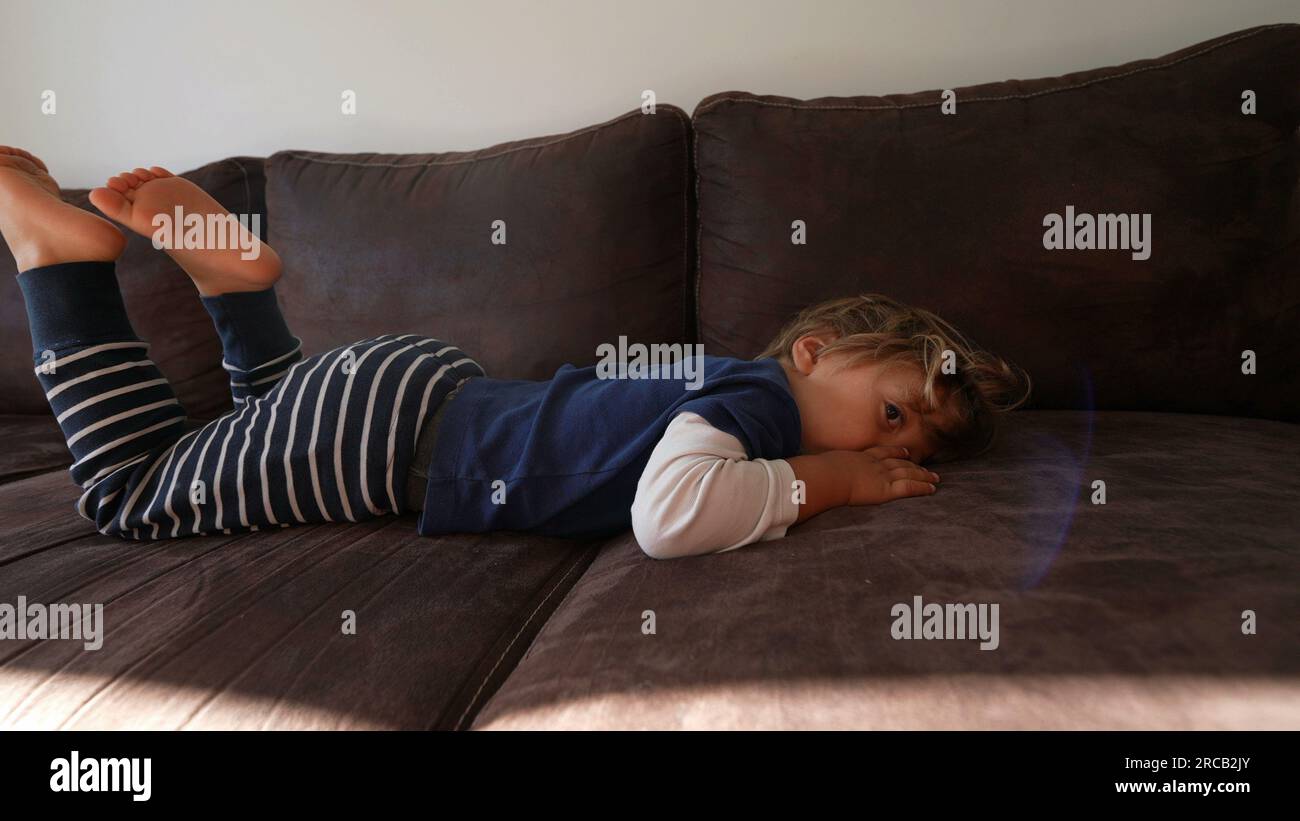 One little boy lying on sofa resting pensive child lies on couch Stock ...