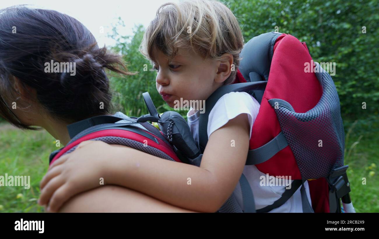 Mother carrying son in backpack carrier mom hiking with child in nature ...