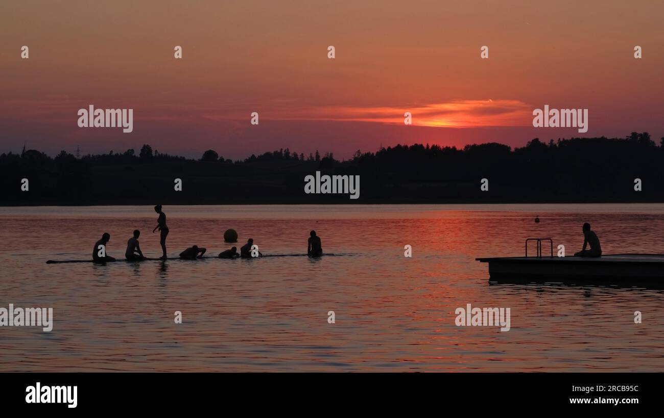 People swimming at sunset, summer scene Stock Photo - Alamy