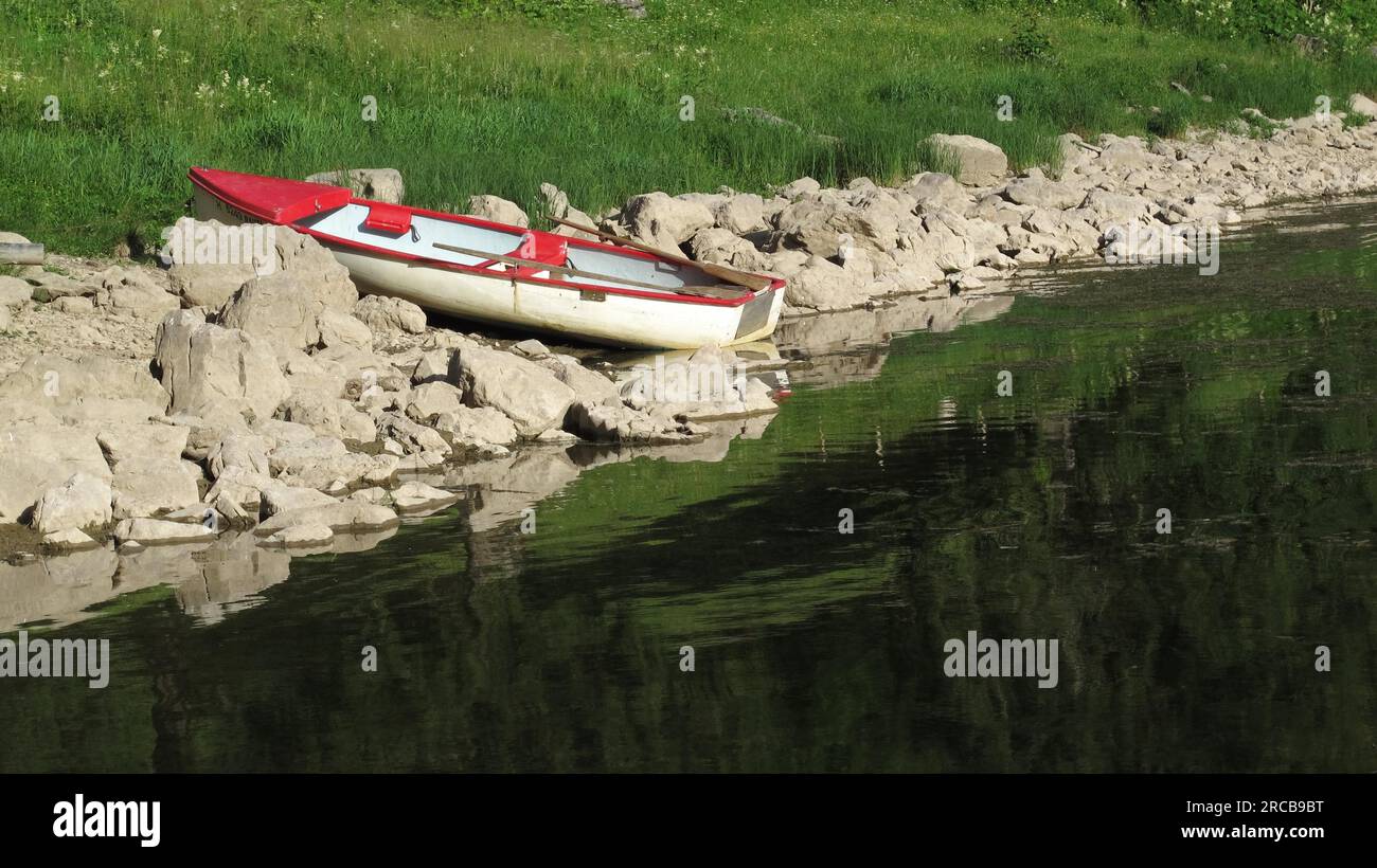 Little row boat on the shore of a lake Stock Photo - Alamy