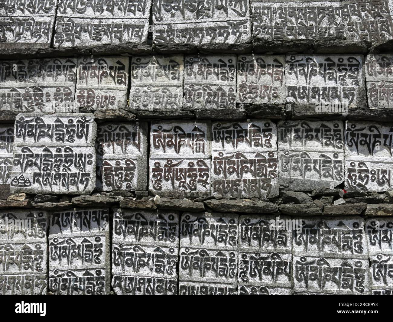 Mani wall, buddhist mantra carved in stones Stock Photo - Alamy