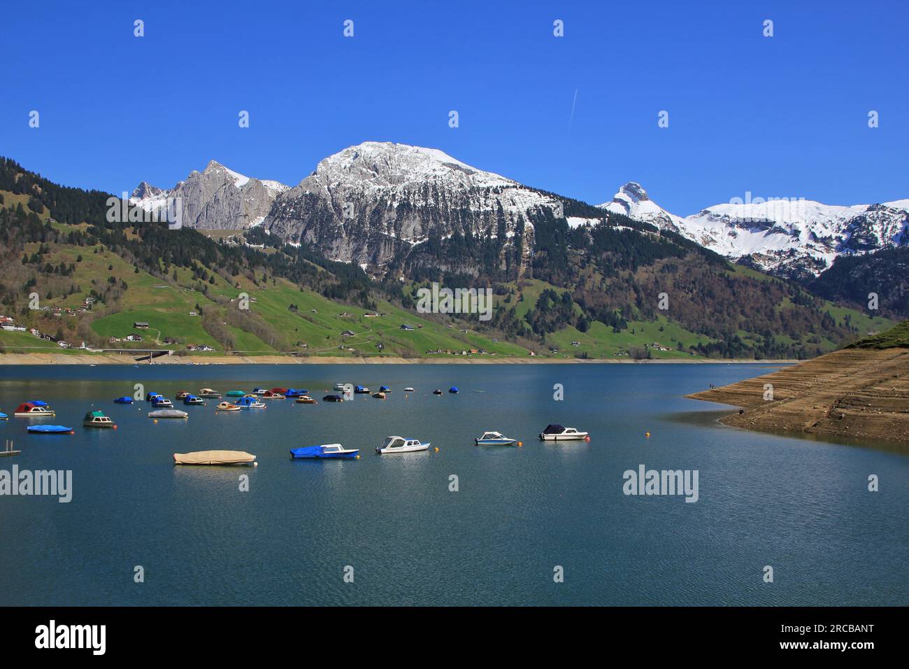 Spring scene in the Swiss Alps. Lake Waegital and snow capped mountains ...