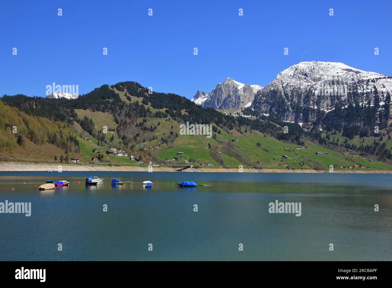 Spring scene in the Swiss Alps. Lake Waegital and snow capped mountains ...