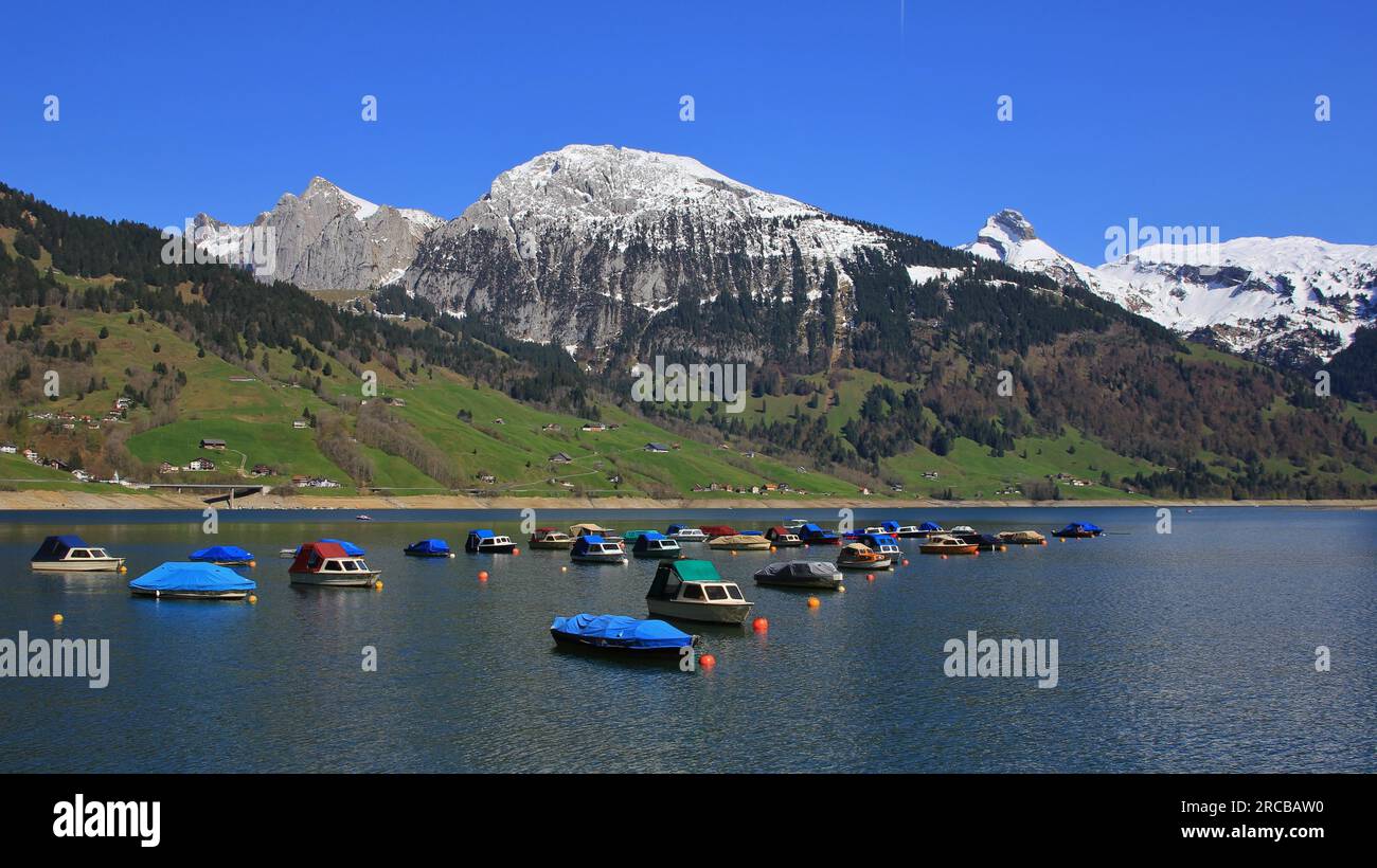 Boats on lake Wagital. Small village Innerthal and snow capped ...