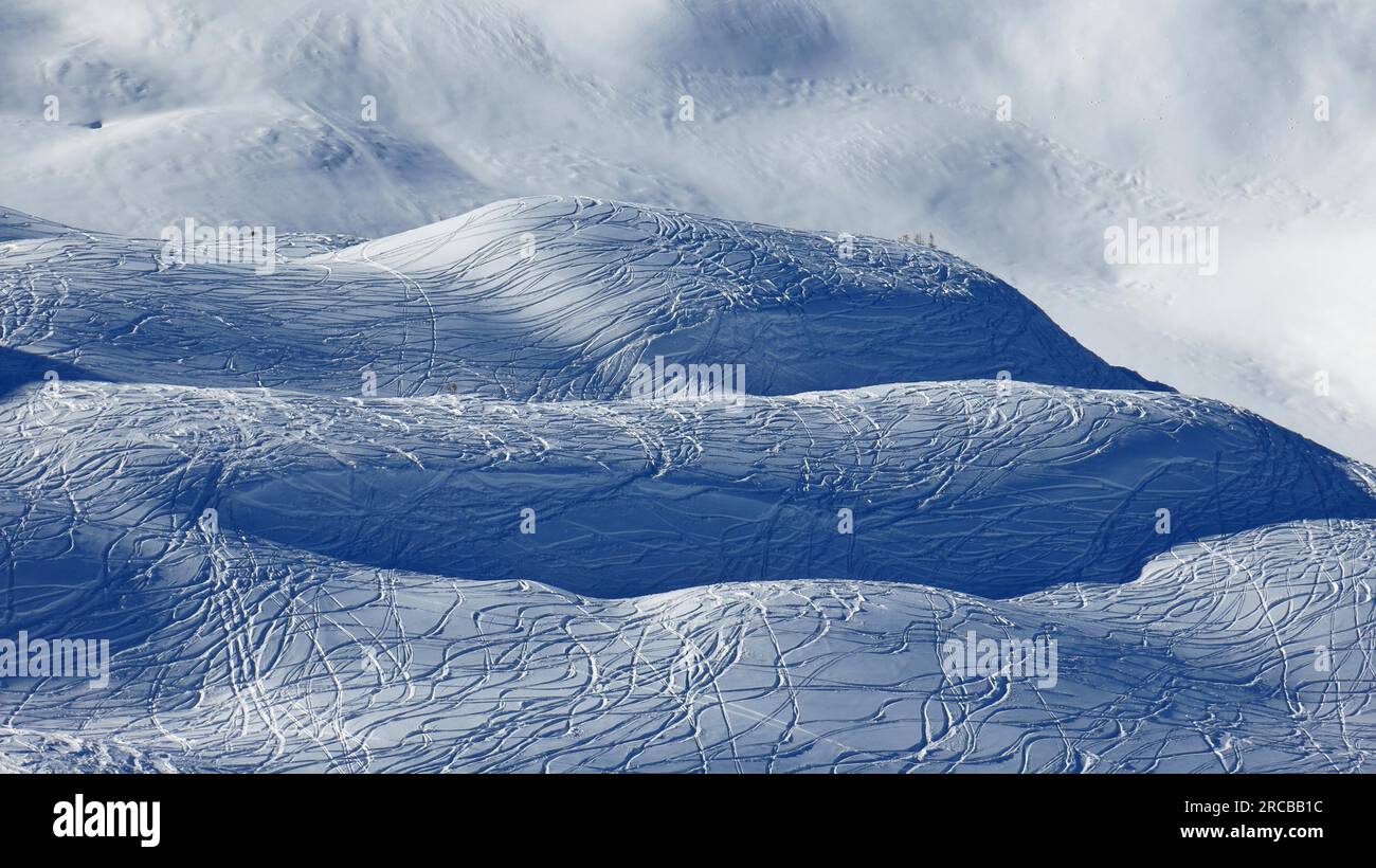 Hills covered with ski and snowboard tracks. Powder snow. Scene in the ...