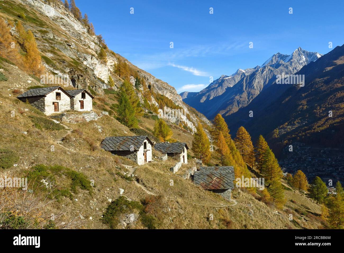 Autumn scene in Zermatt. Golden larch forest, old huts and high ...
