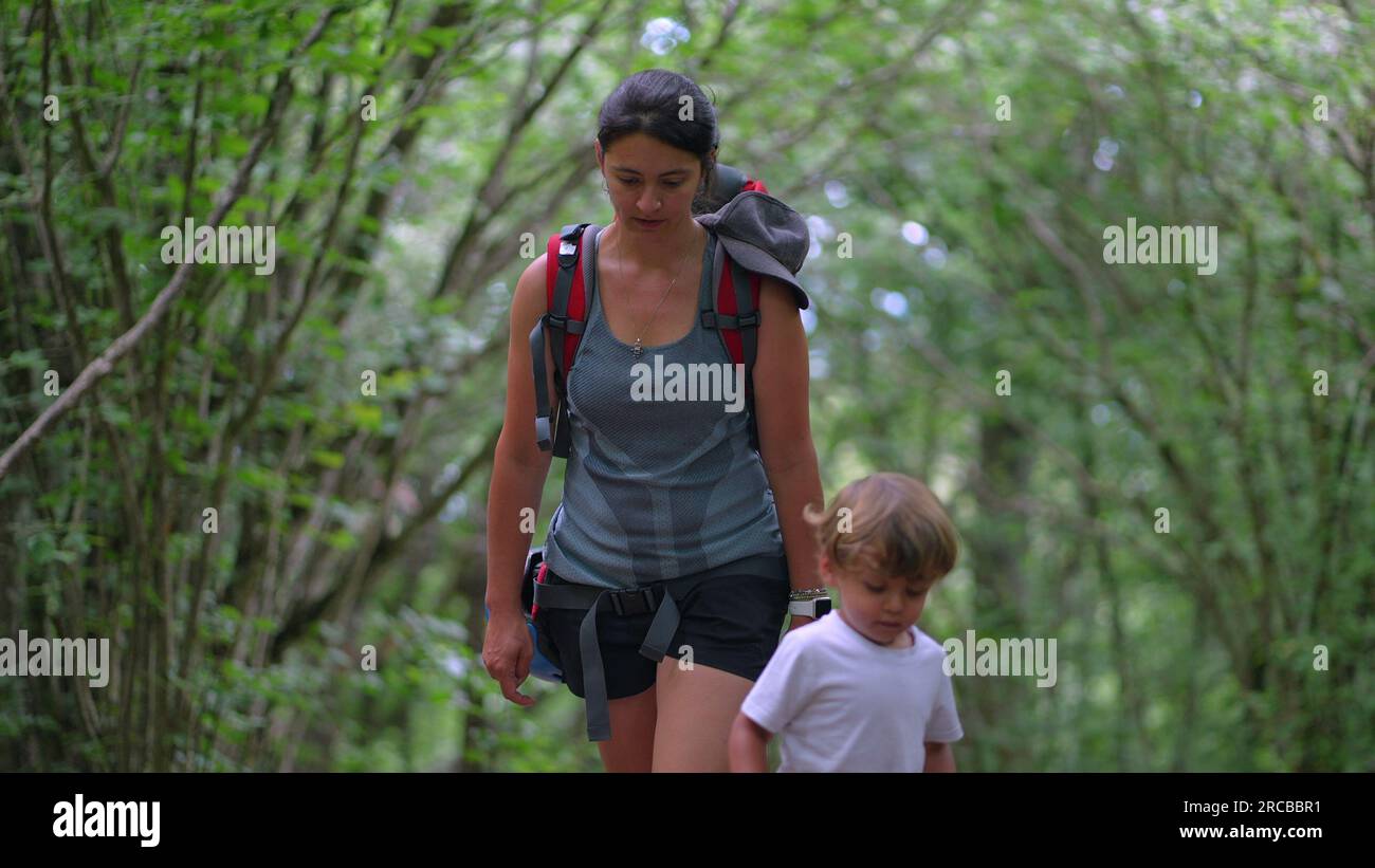 Child hiking with mother outside in forest nature kid hiker climbing ...