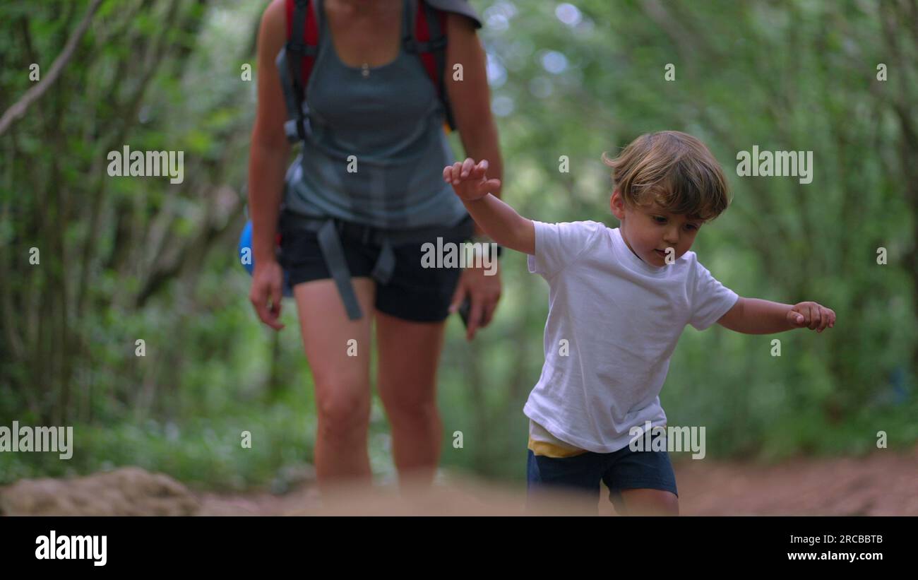 Child hiking with mother outside in forest nature kid hiker climbing ...