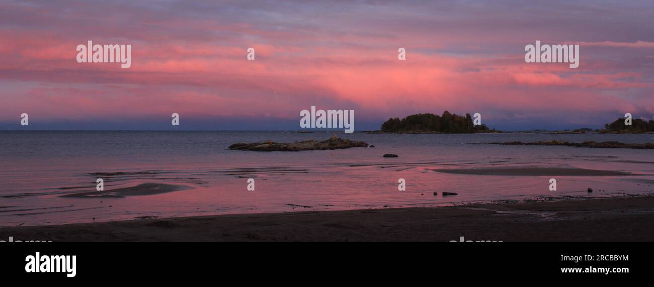 Summer evening in Vita Sannar, Sweden. Bright pink clouds over Lake ...