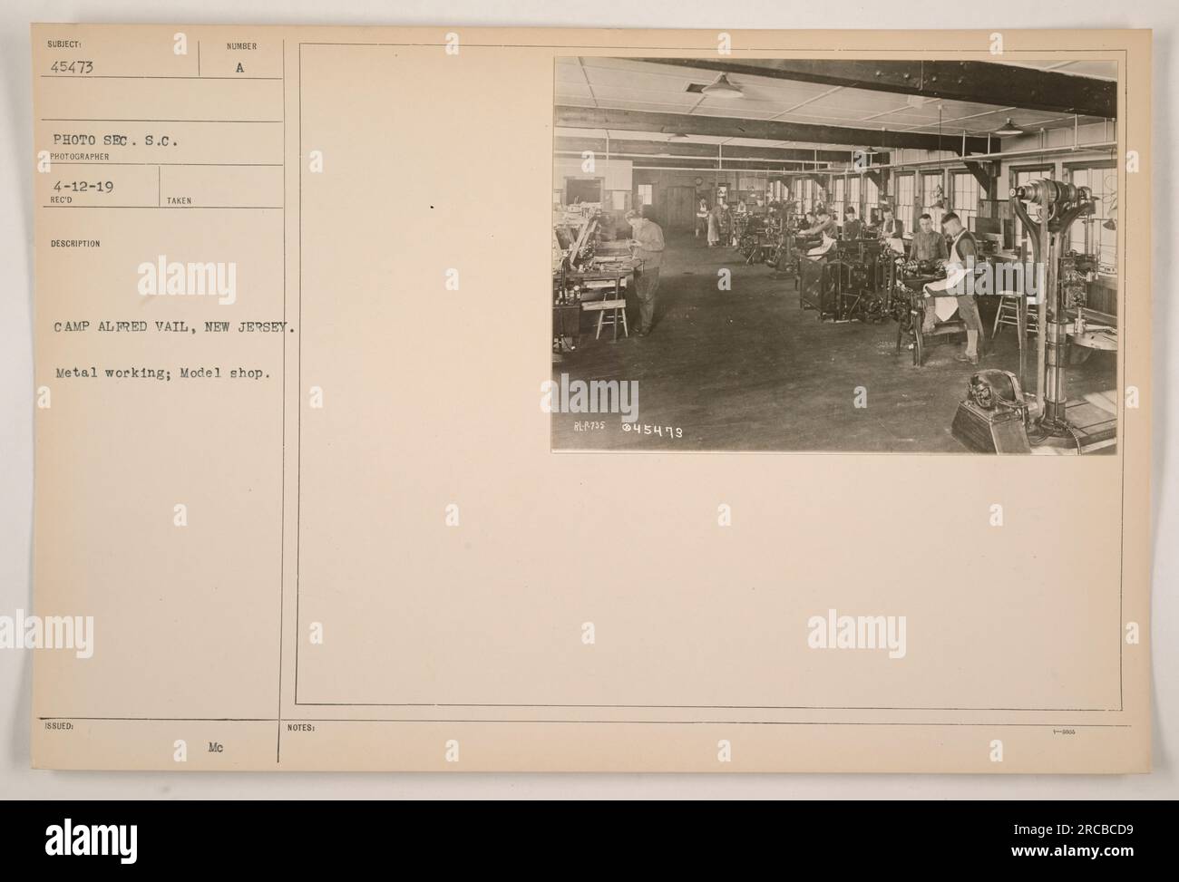 Workers busy in a metalworking model shop at Camp Alfred Vail, New ...