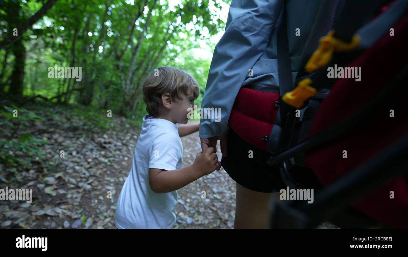 Child holding mother hand while hiking parent and kid bonding while ...