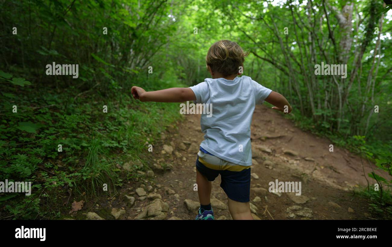 Child playing in nature running in woods path Stock Photo - Alamy