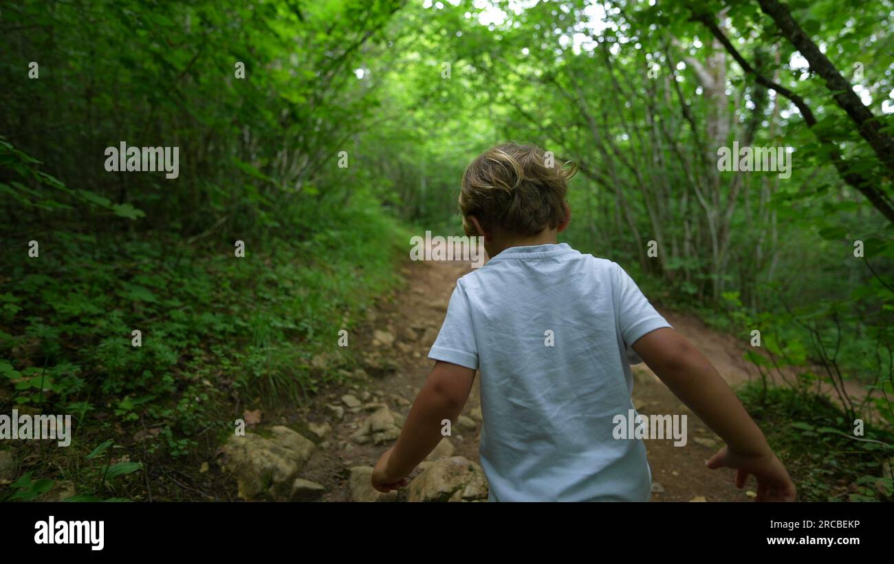 Child playing in nature running in woods path Stock Photo - Alamy