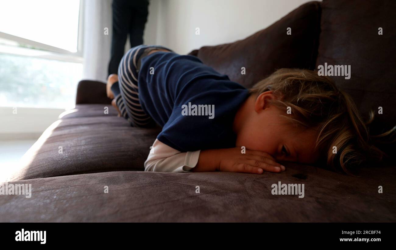Child getting up from sofa after rest with sunlight lens flare Stock ...