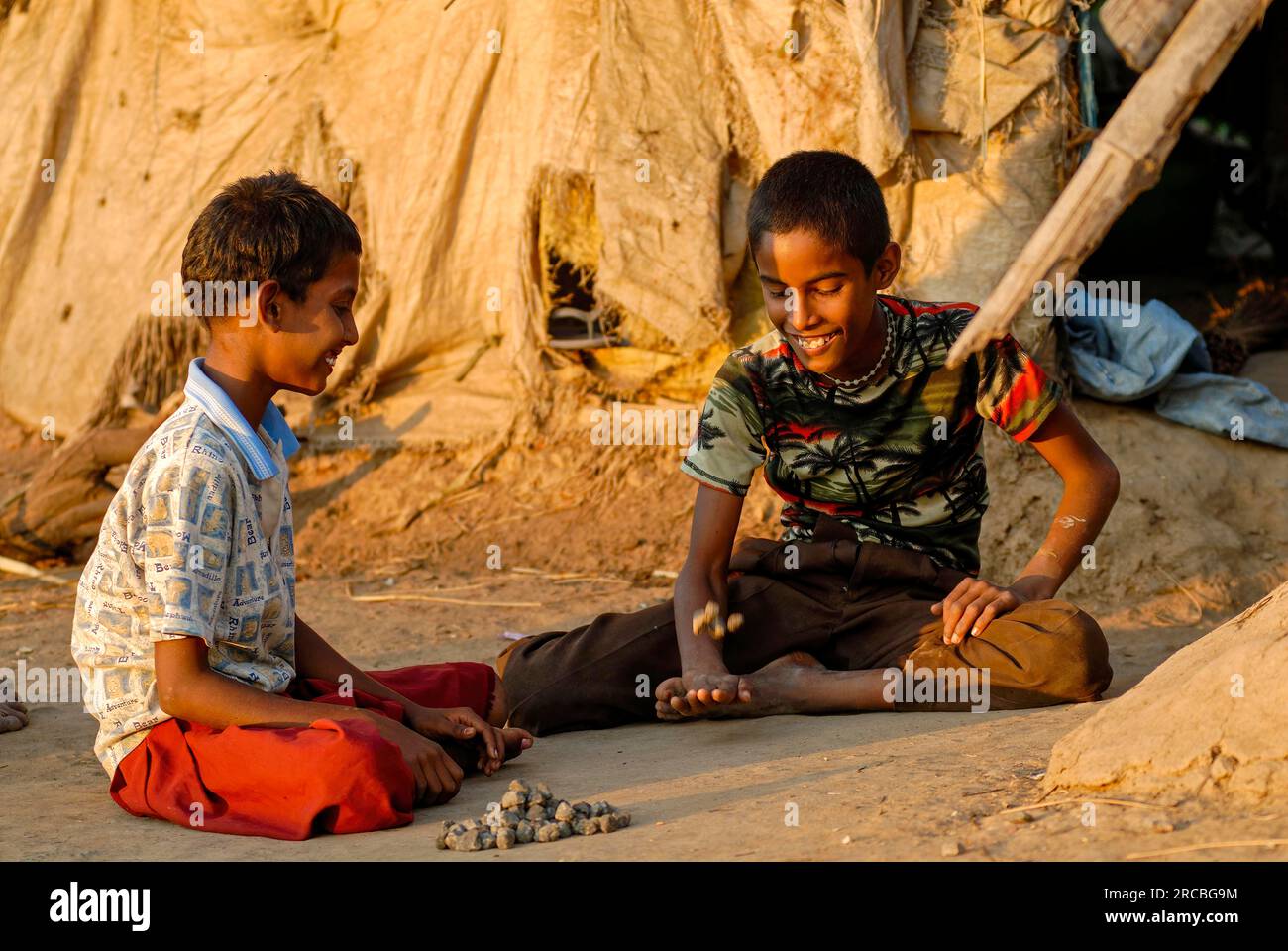 Rural children playing with stone near Vadalur, Neyveli, Tamil Nadu ...
