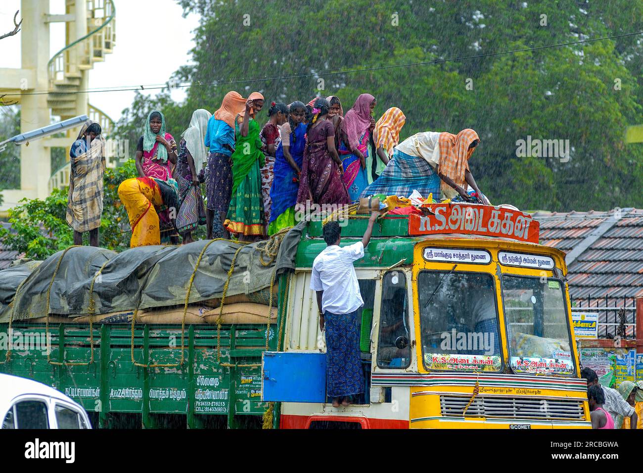 Labourers travelling on a lorry during a rainy day, Tamil Nadu, South ...