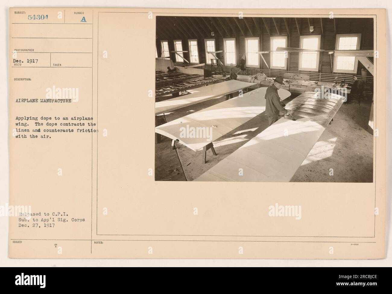 In this image, a worker applies dope to an airplane wing. The dope ...