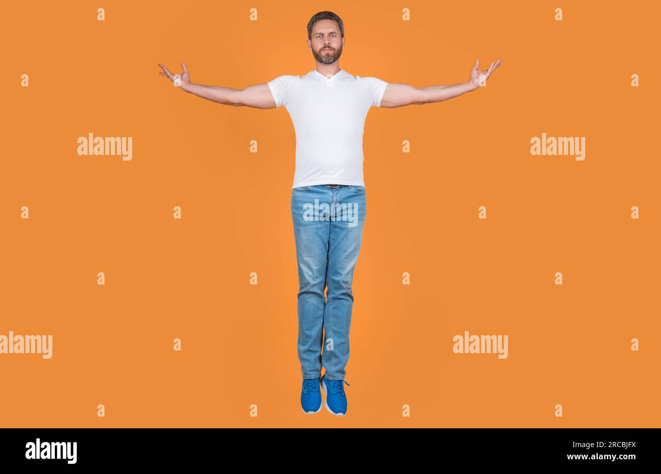 Handsome man levitating yellow background. Grizzled guy levitating ...