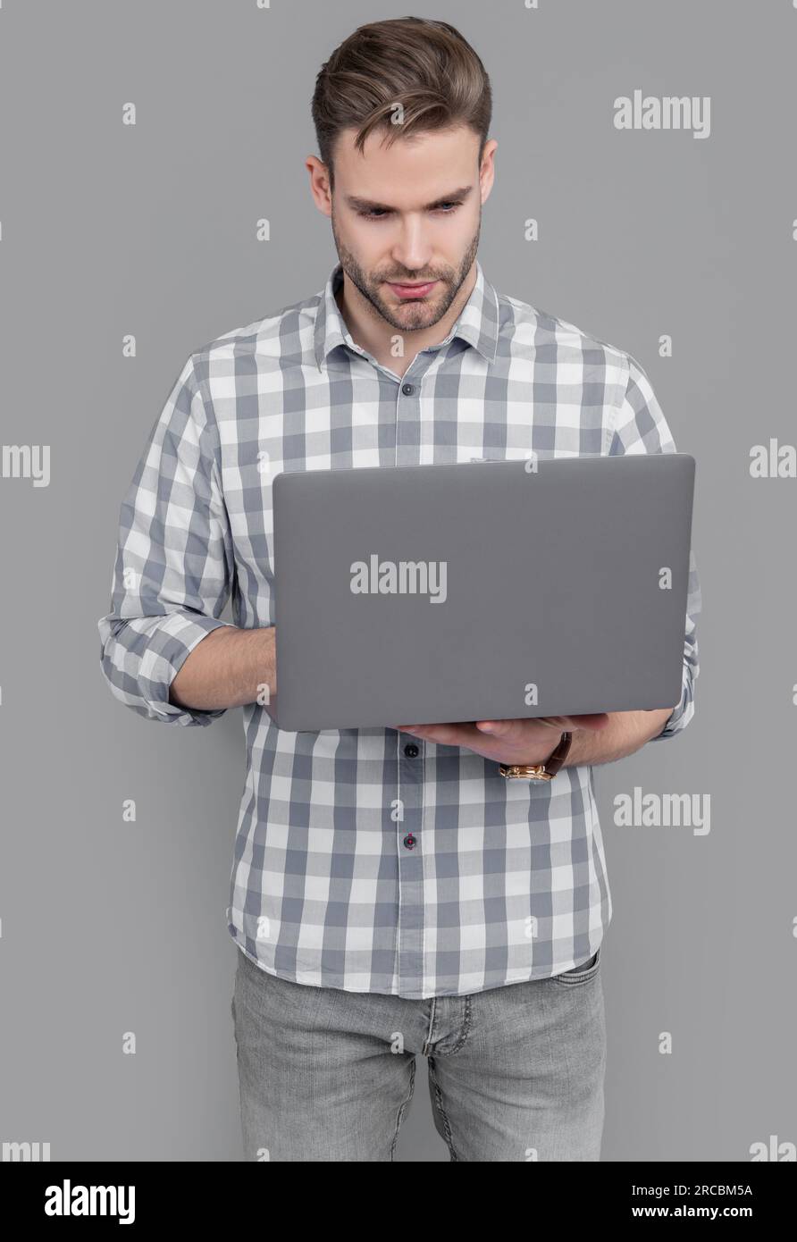 Computer programmer studio. Software developer using laptop computer. Serious man typing in ...