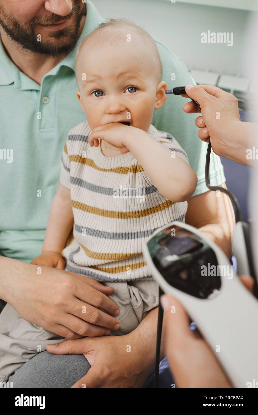 Child having hearing exam at otolaryngologist. Examining little patient ...