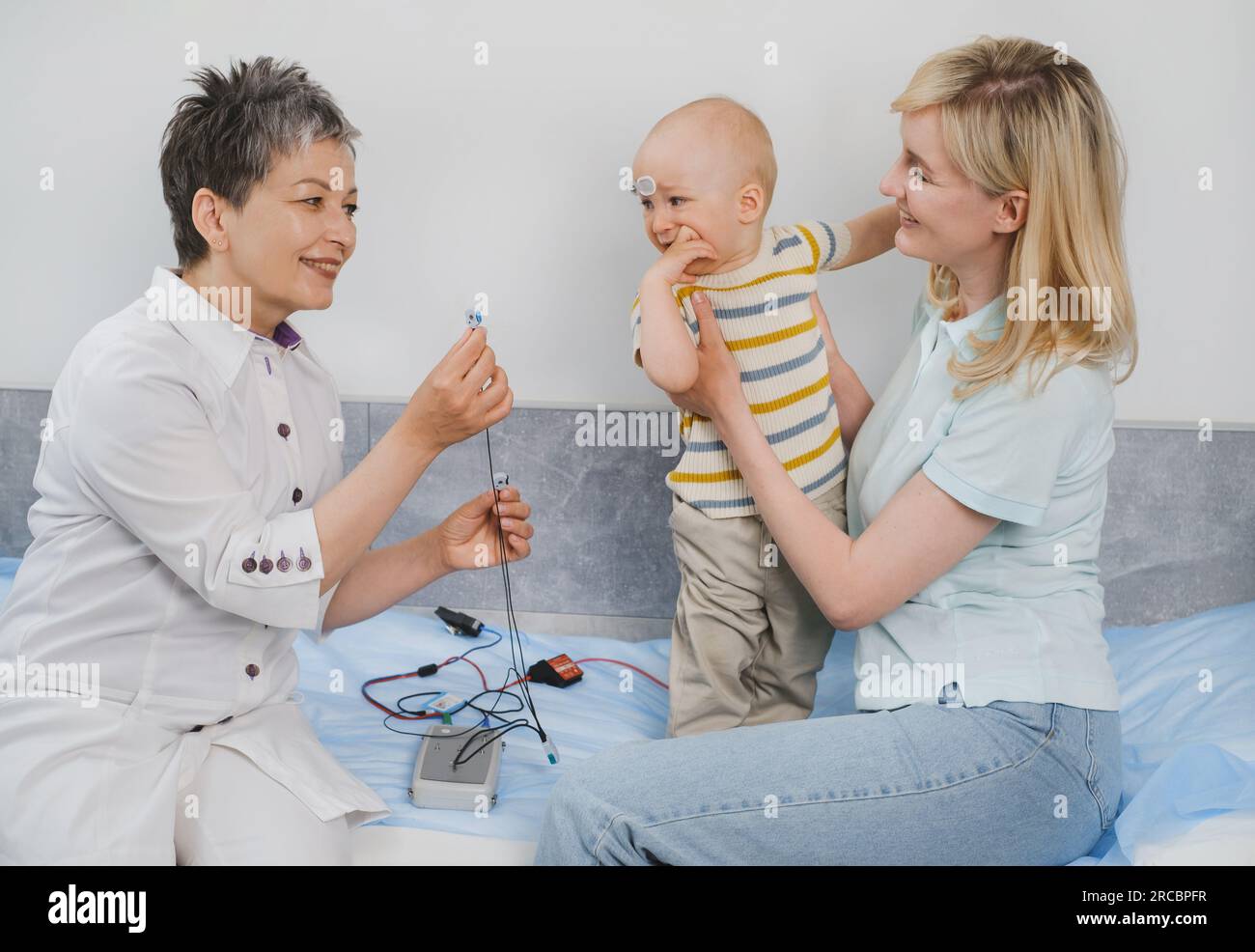 Child having hearing exam at otolaryngologist. Examining little patient ...
