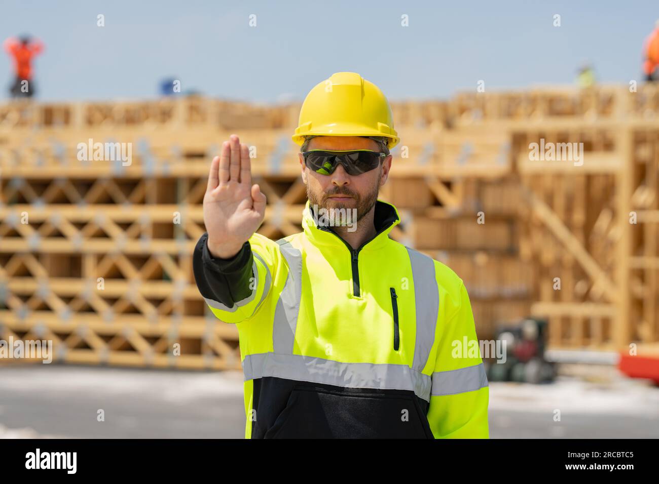 Stop, hand gesture. Worker near american wood frame house construction ...