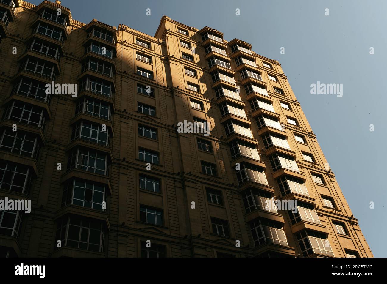 A close-up capture of a historic building bathed in patchy sunlight in ...