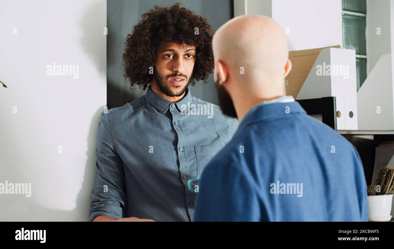 Two workers talking on the work while drinking coffee hi-res stock ...