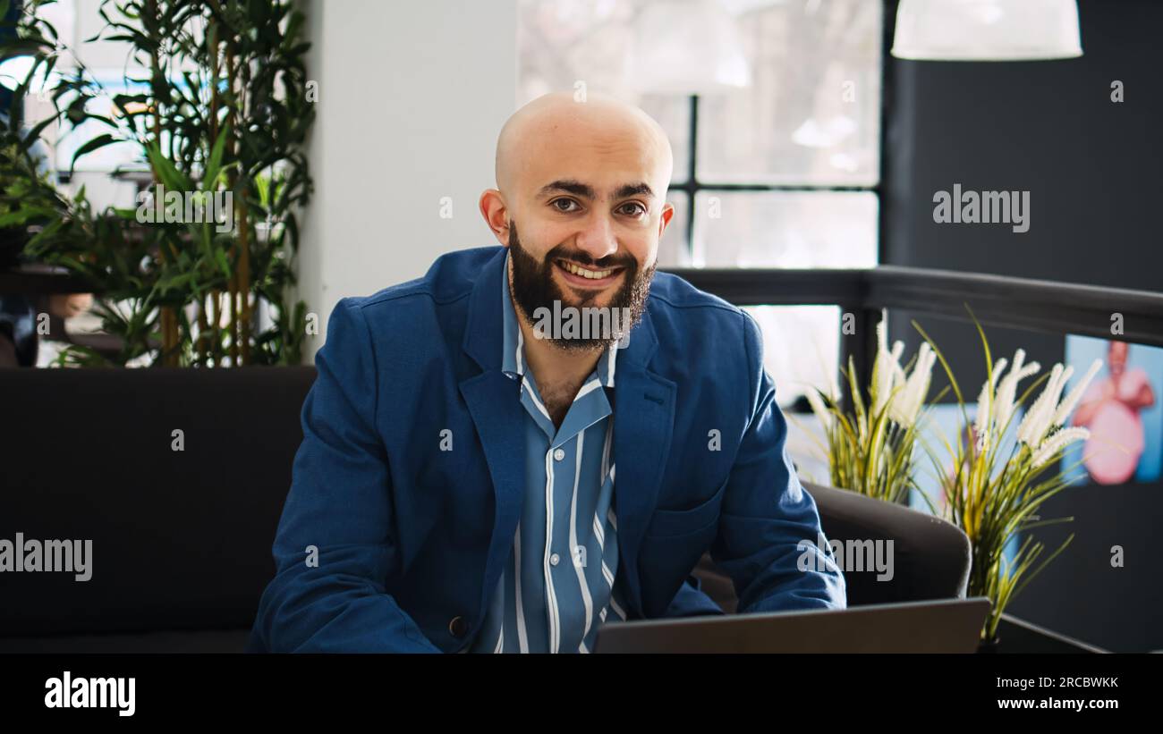 Startup worker uses laptop in open space, reviewing project data on ...