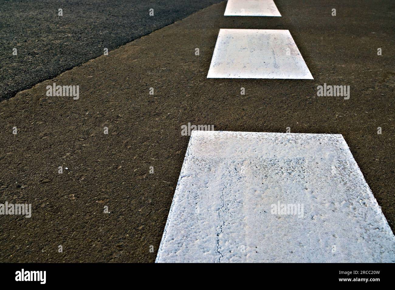 Broad dashed white line in perspective painted with reflective paint on ...