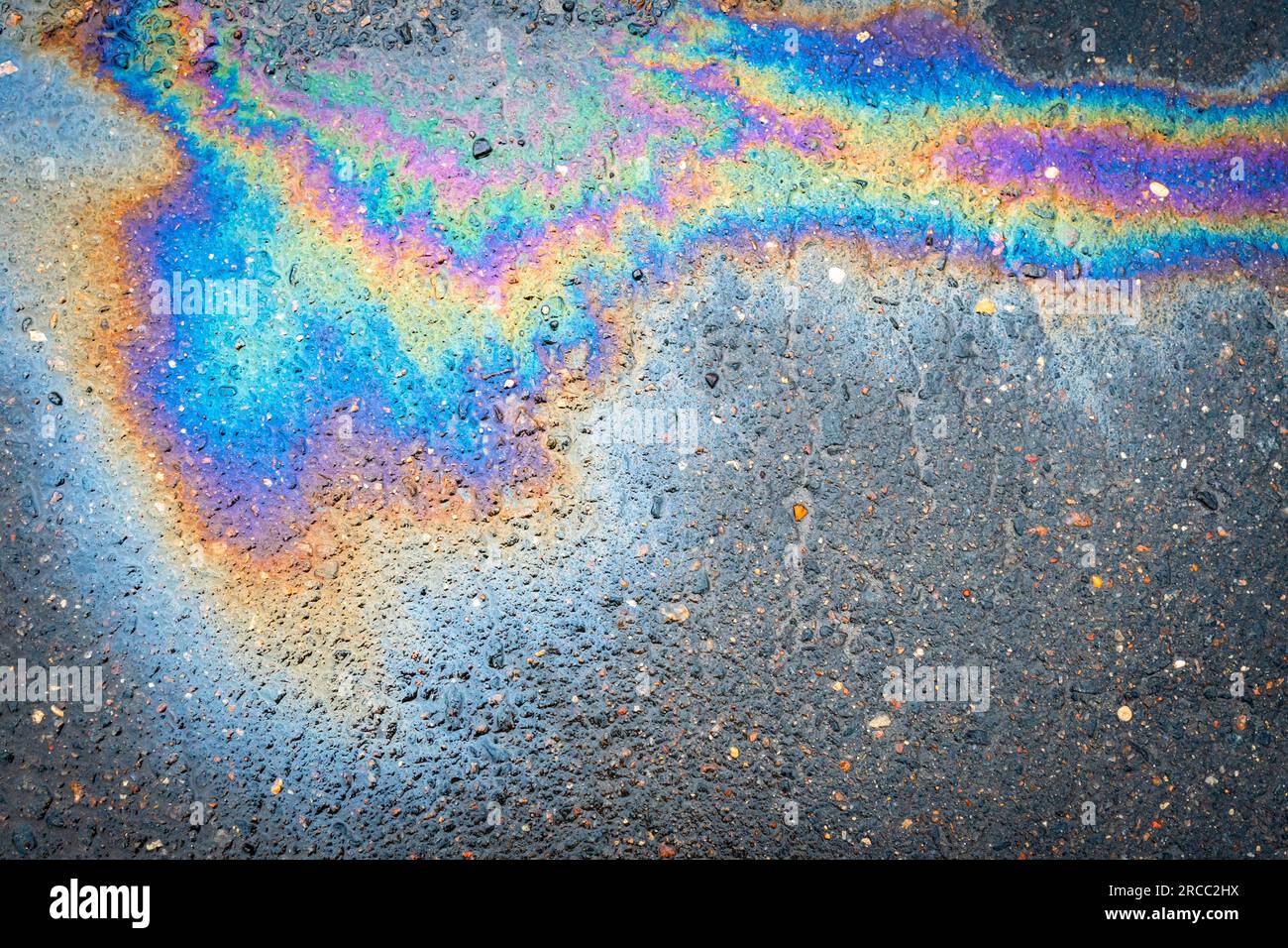 Oil stain on the asphalt, rainbow-shaped colored gasoline stains on an ...