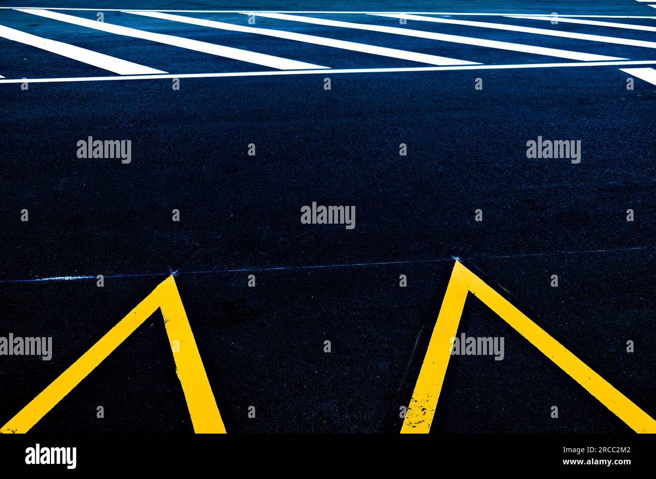 Abstract section of road surface with yellow parking space and white ...