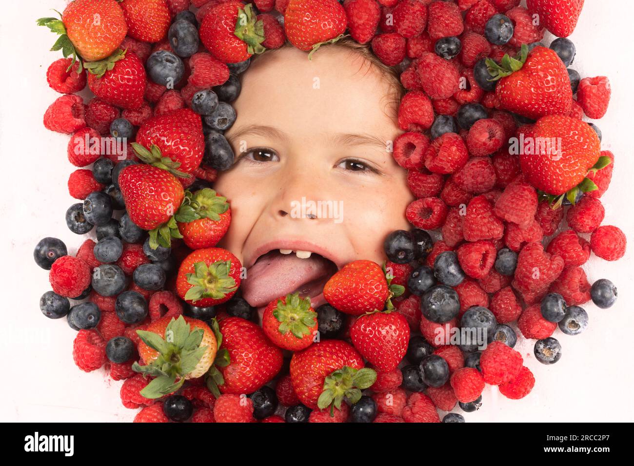 Healthy vitamins fruits. Kids face with close-up berry. Berries mix of ...