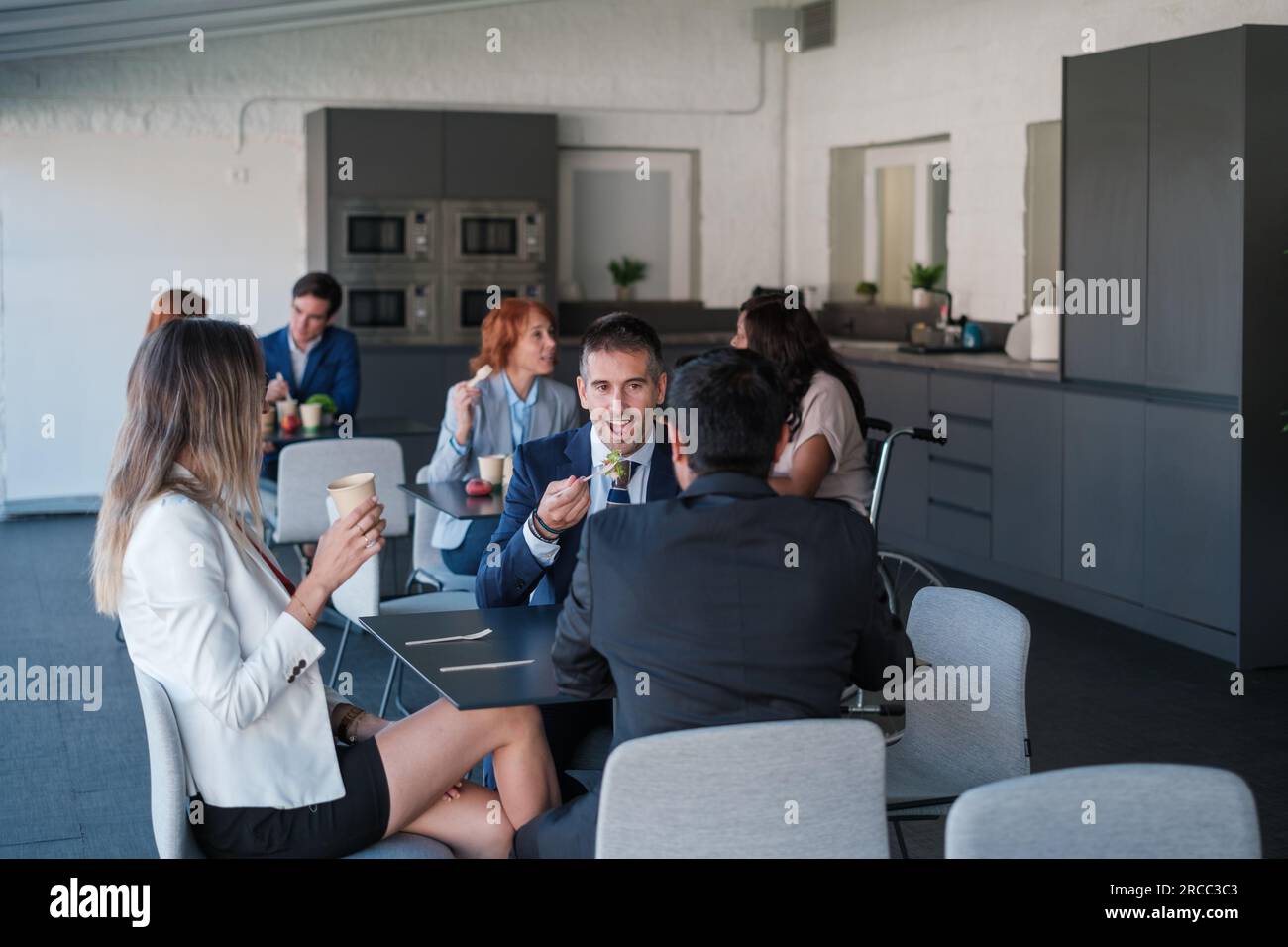 Group of workers in the common areas sharing moments and eating during ...