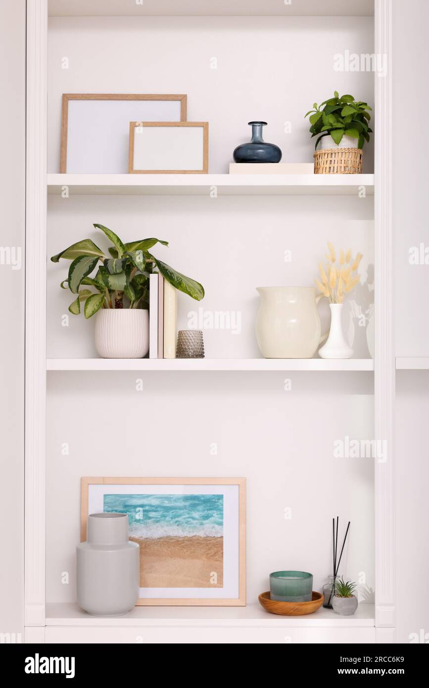 Interior design. Shelves with stylish accessories, potted plants and ...