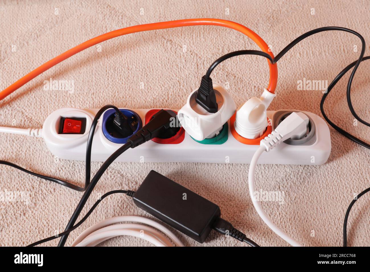 Power strip with different electrical plugs on white carpet Stock Photo ...