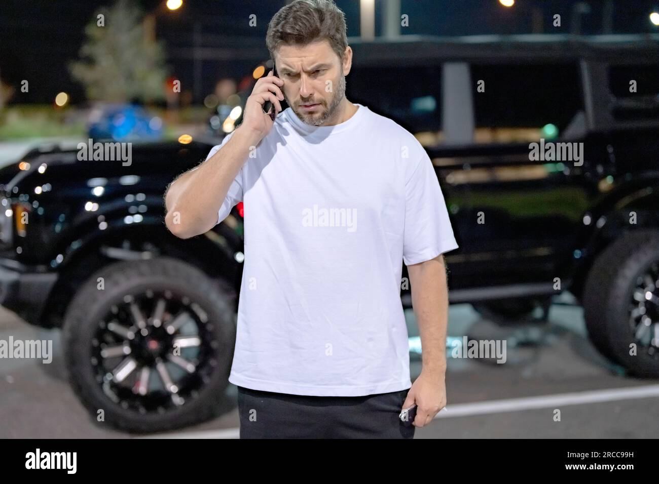 Serious man talking on phone outdoor. Serious hipster talking on phone ...