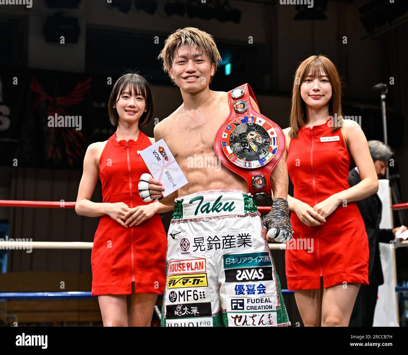 Tokyo, Japan. 11th July, 2023. Japan's Taku Kuwahara, center, poses with ring girls Yui Arata ...