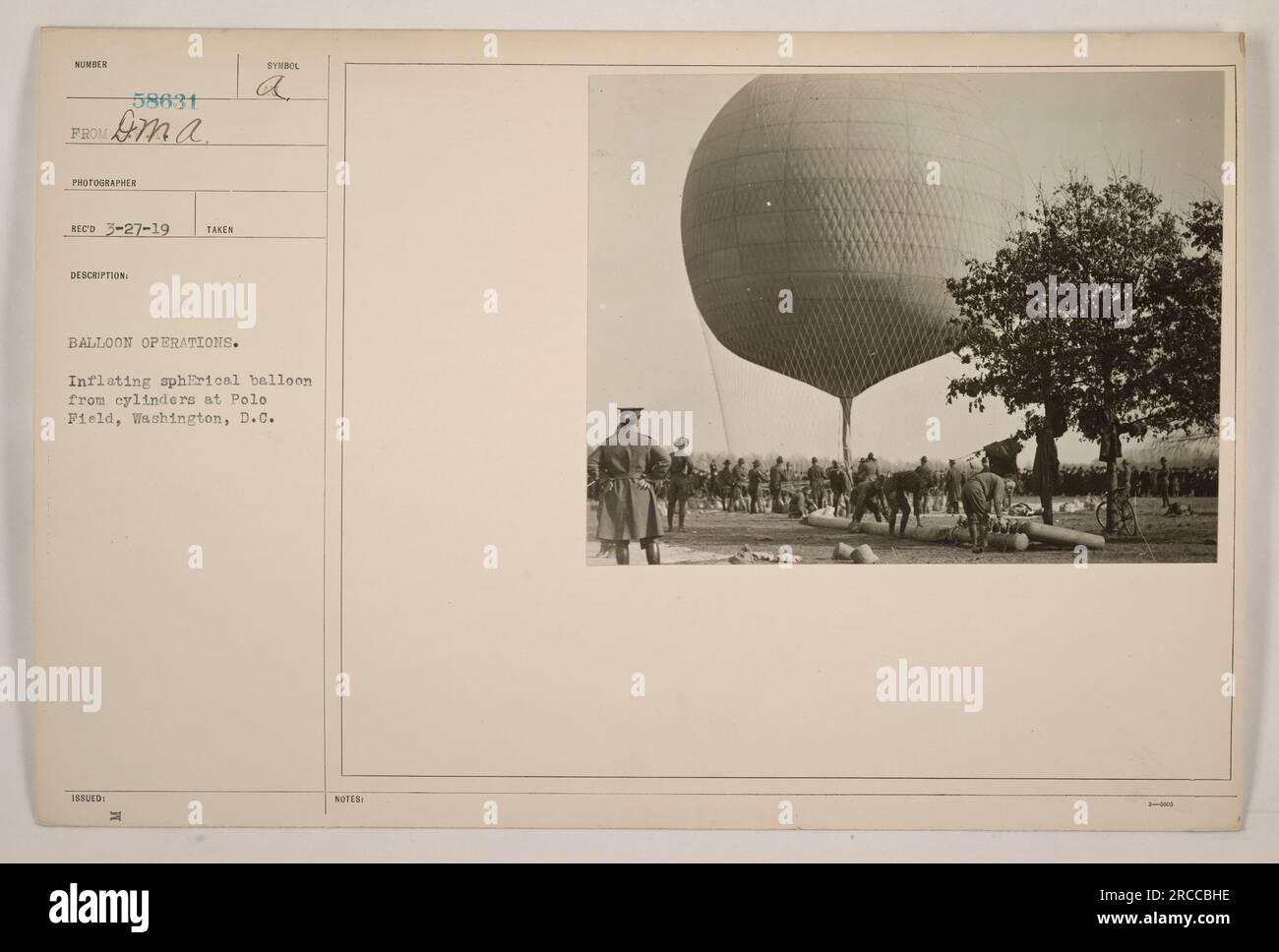 American military personnel inflating a spherical balloon using ...