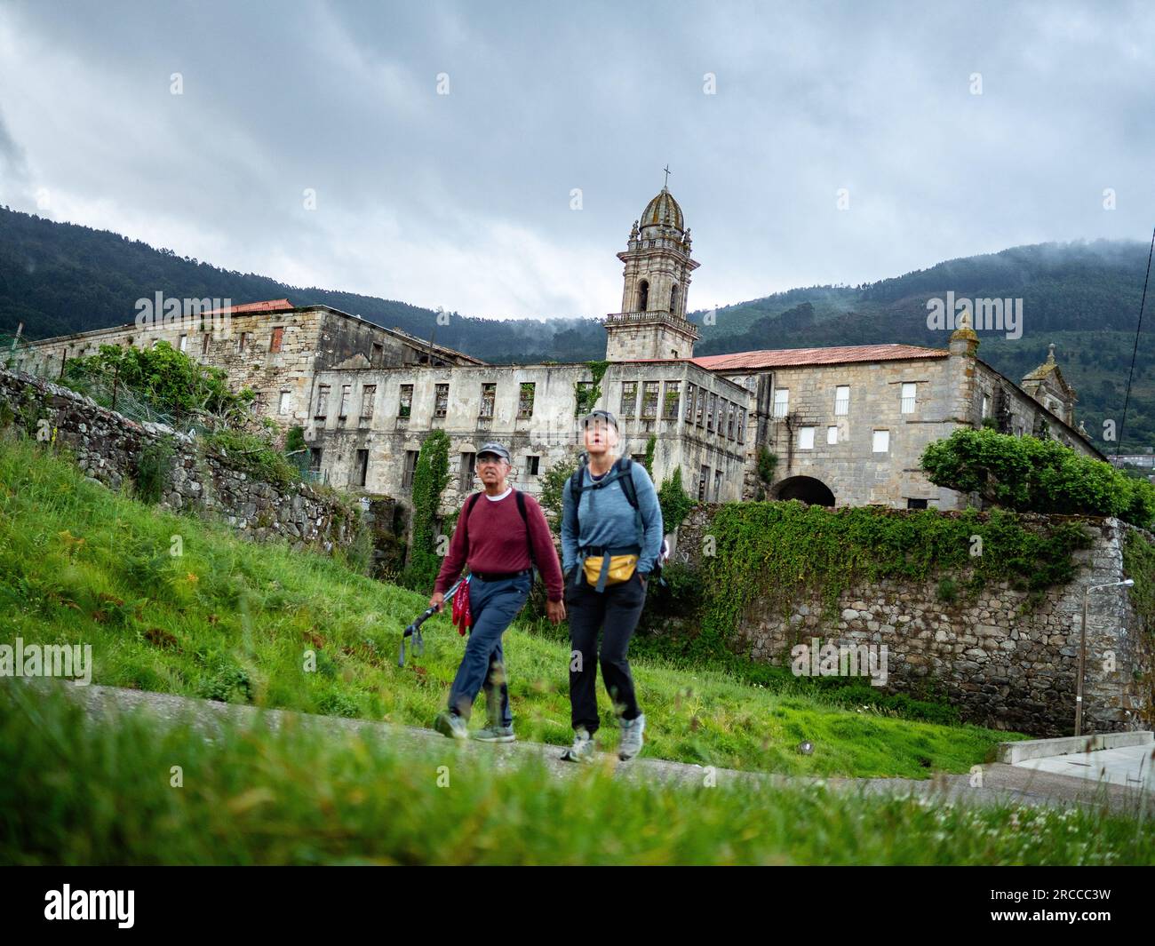 Two pilgrims are seen passing by an old monastery. The Coastal Route of ...