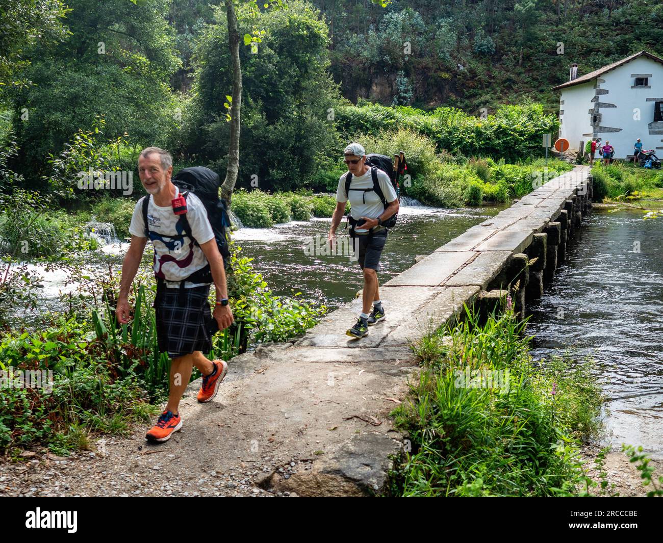 Two Scottish pilgrims are seen crossing an old bridge. The Coastal ...